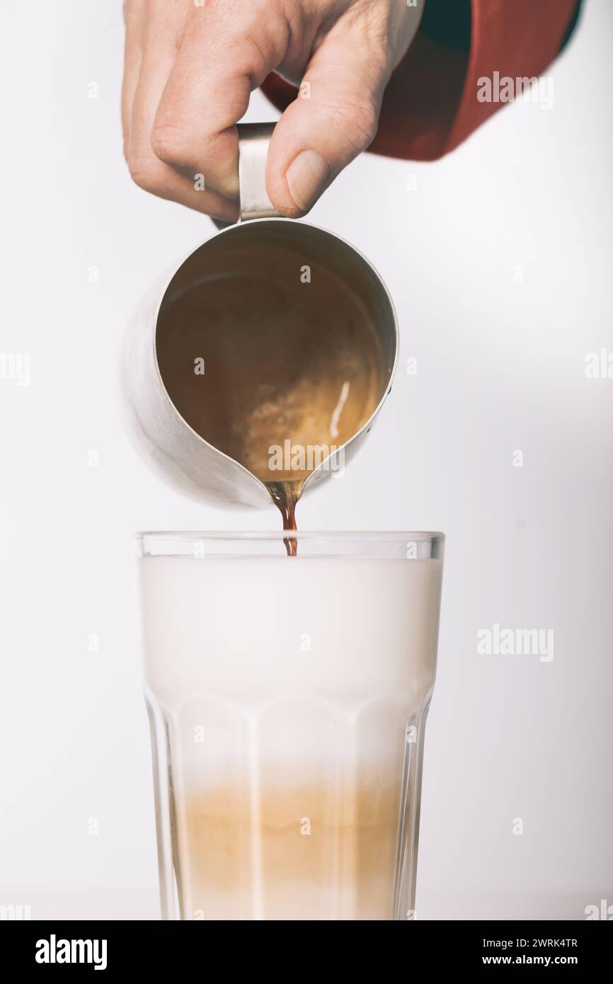 Preparing a caffe latte style hot drink from espresso and milk Stock Photo - Alamy