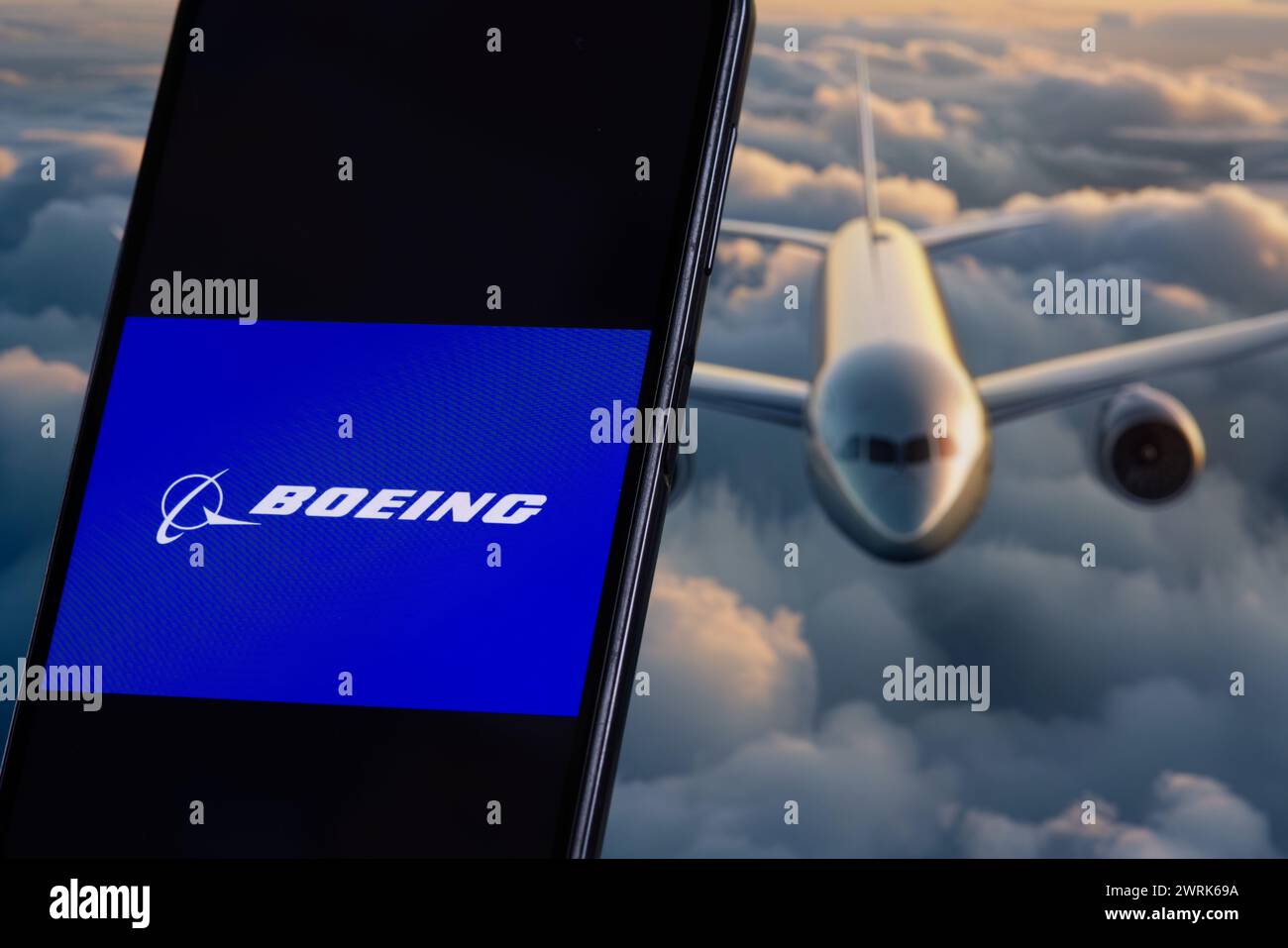 Logo of Boeing is sharp in the foreground, while the flying jet in the ...