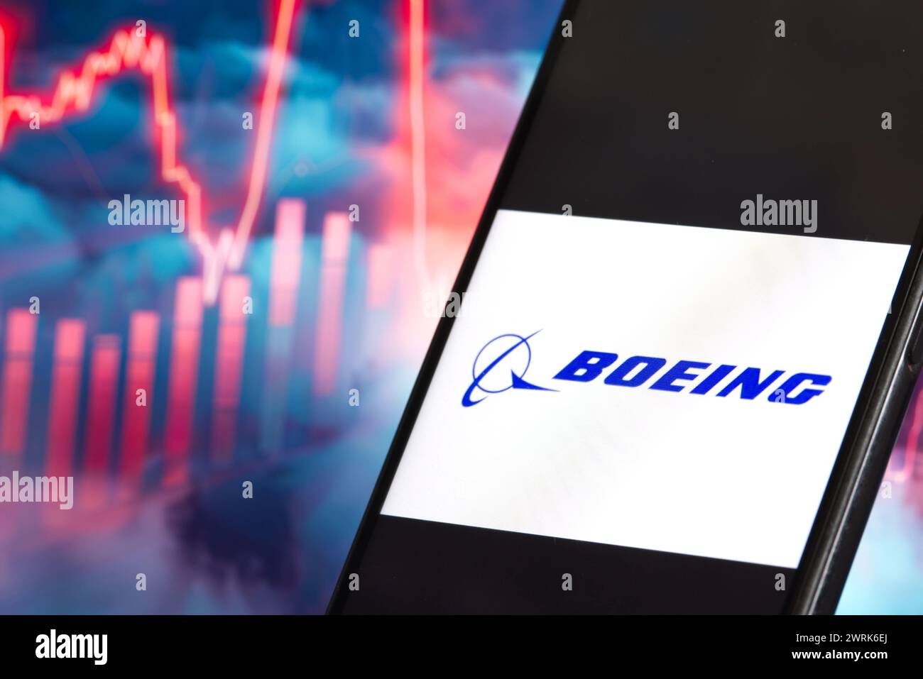 Logo of Boeing is sharp in the foreground, while the stock chart in the ...