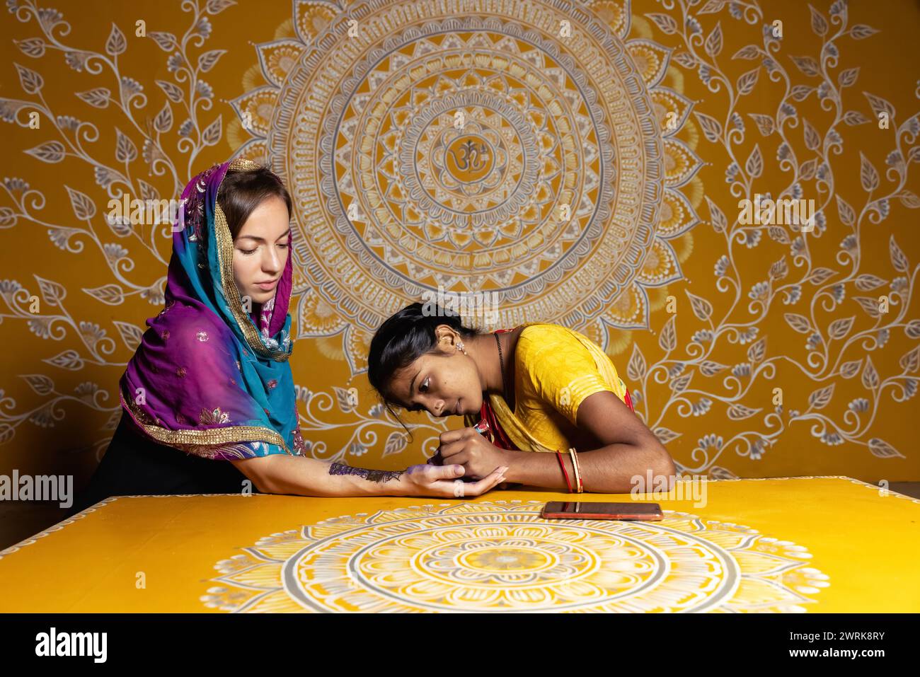 Indian artisan is applying mehndi on the hands of a white skin bride ...