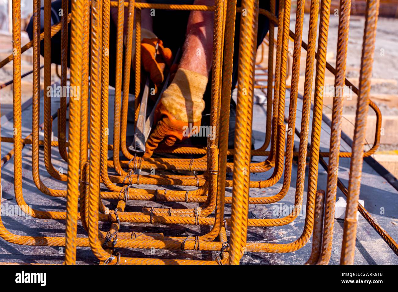 Worker is tying rebar with wire using pliers, to make a reinforcing ...