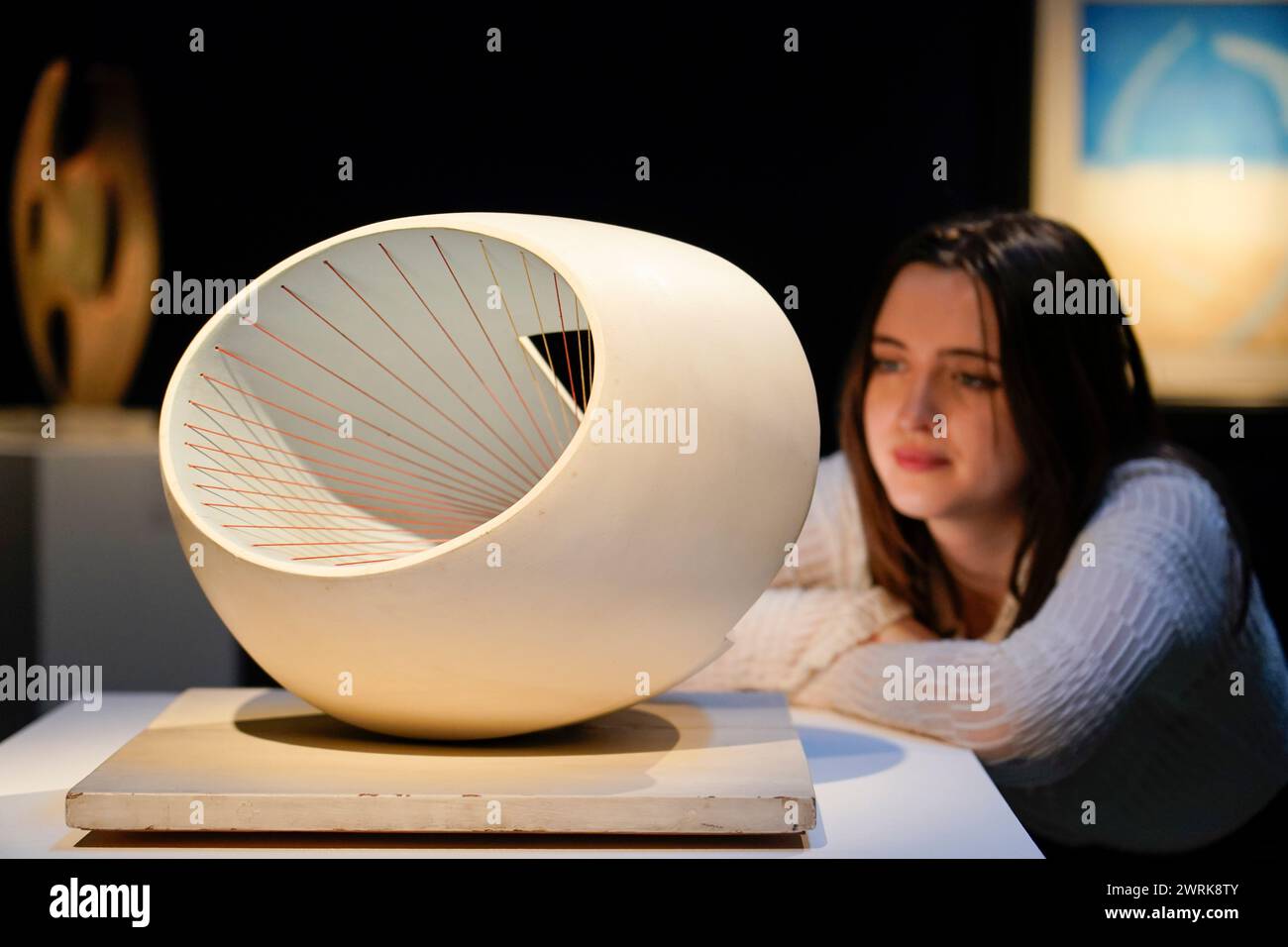 A member of staff poses next to the Sculpture with Colour (Oval Form ...