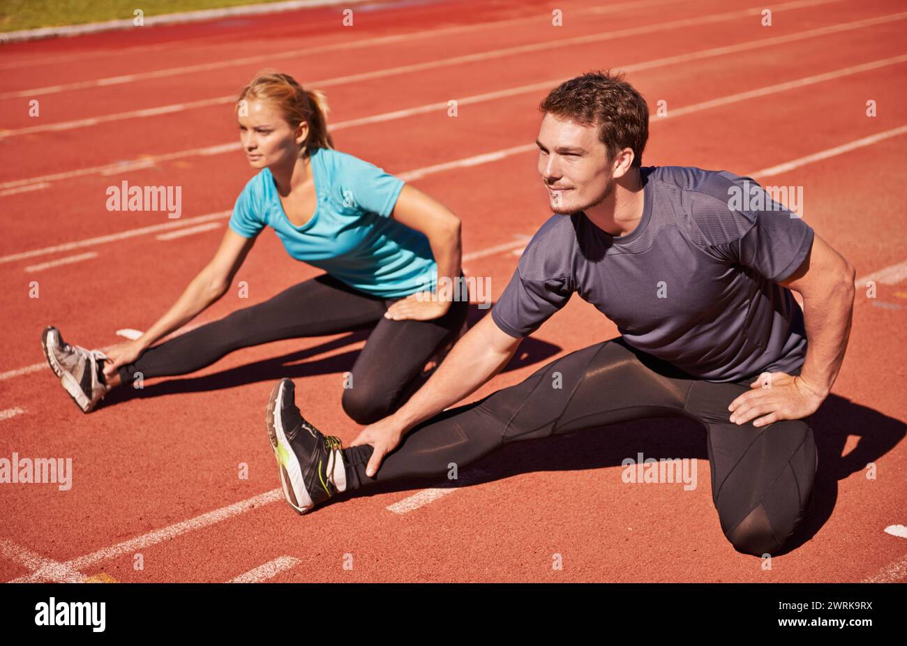 Workout, legs and couple stretching in stadium for race, marathon or ...