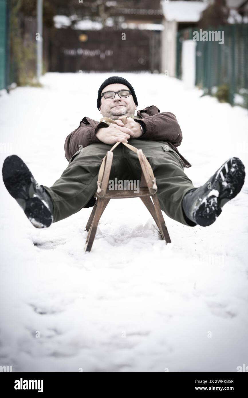 Adult man enjoying winter with classic retro wooden toboggan Stock ...