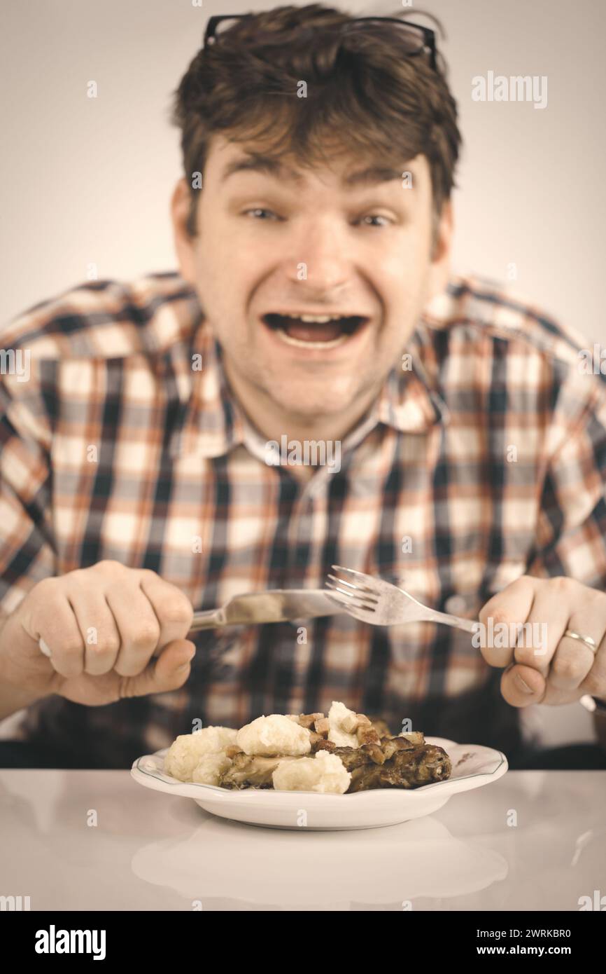 Man eating his lunch made of baked rabbit meat and gnocchi Stock Photo ...