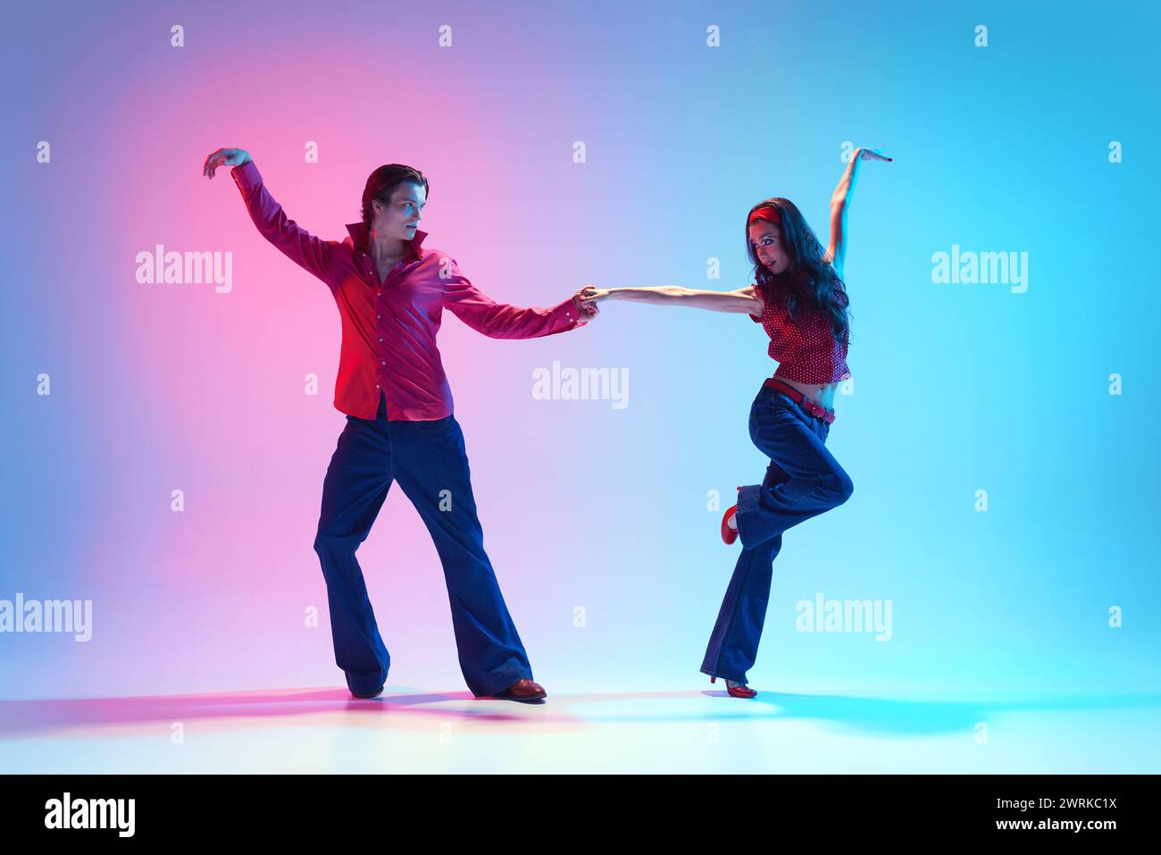 Young stylish people, man and woman dancing retro dance against ...