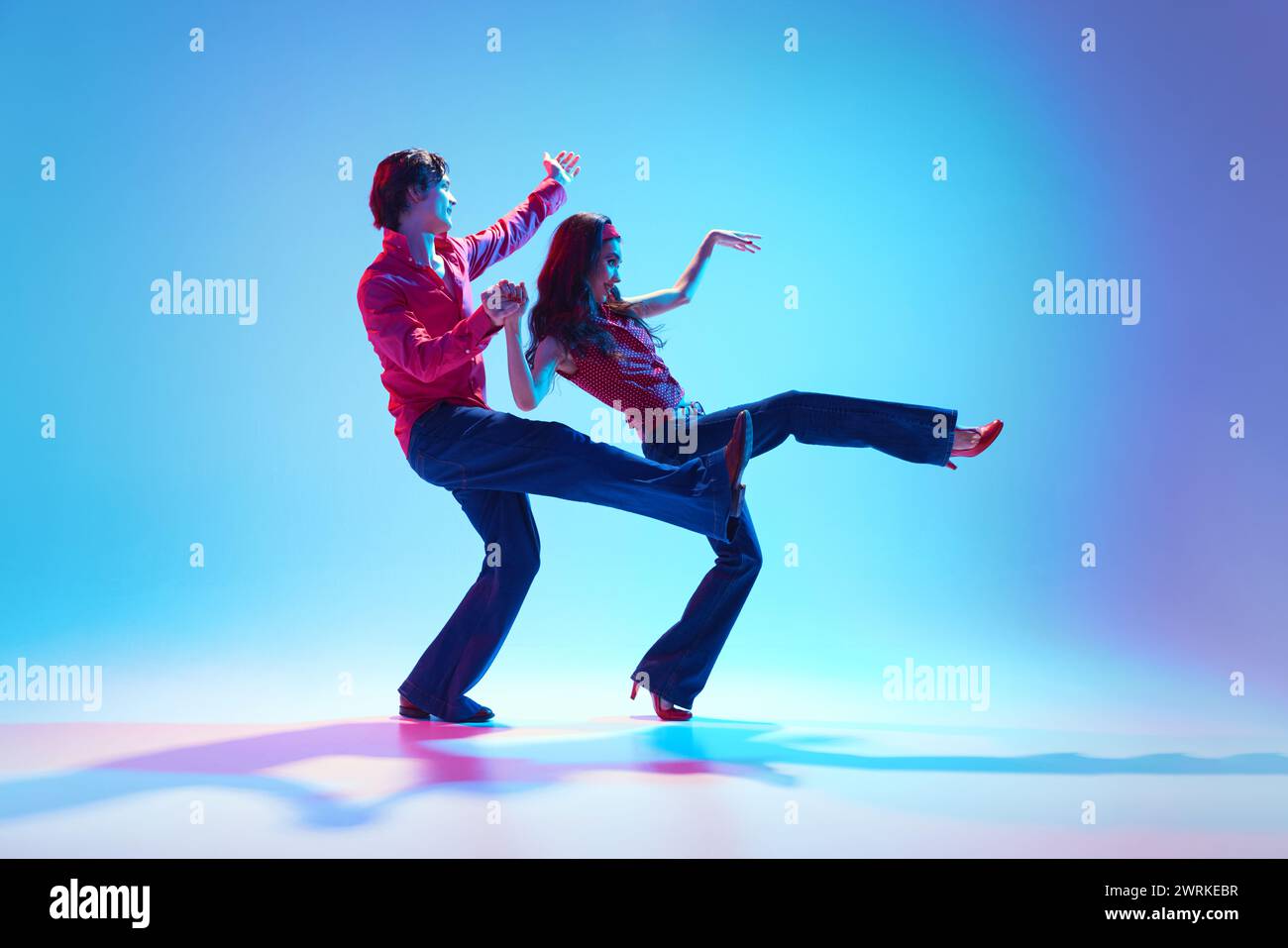 Happy, positive young man and woman in retro clothes dancing boogie ...