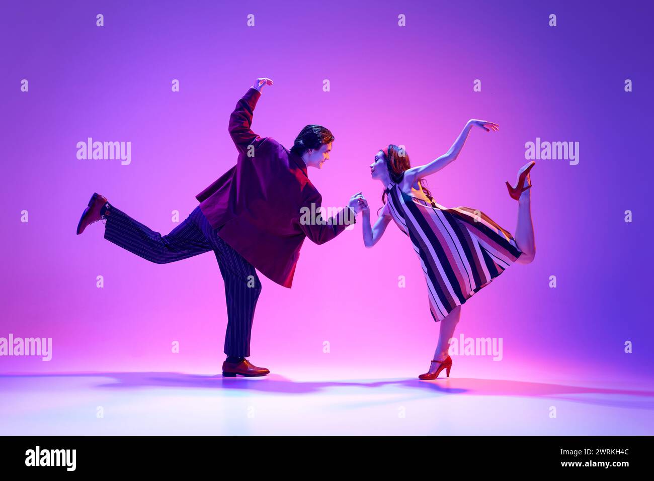 Stylish, beautiful young couple, man and woman in retro clothes dancing ...