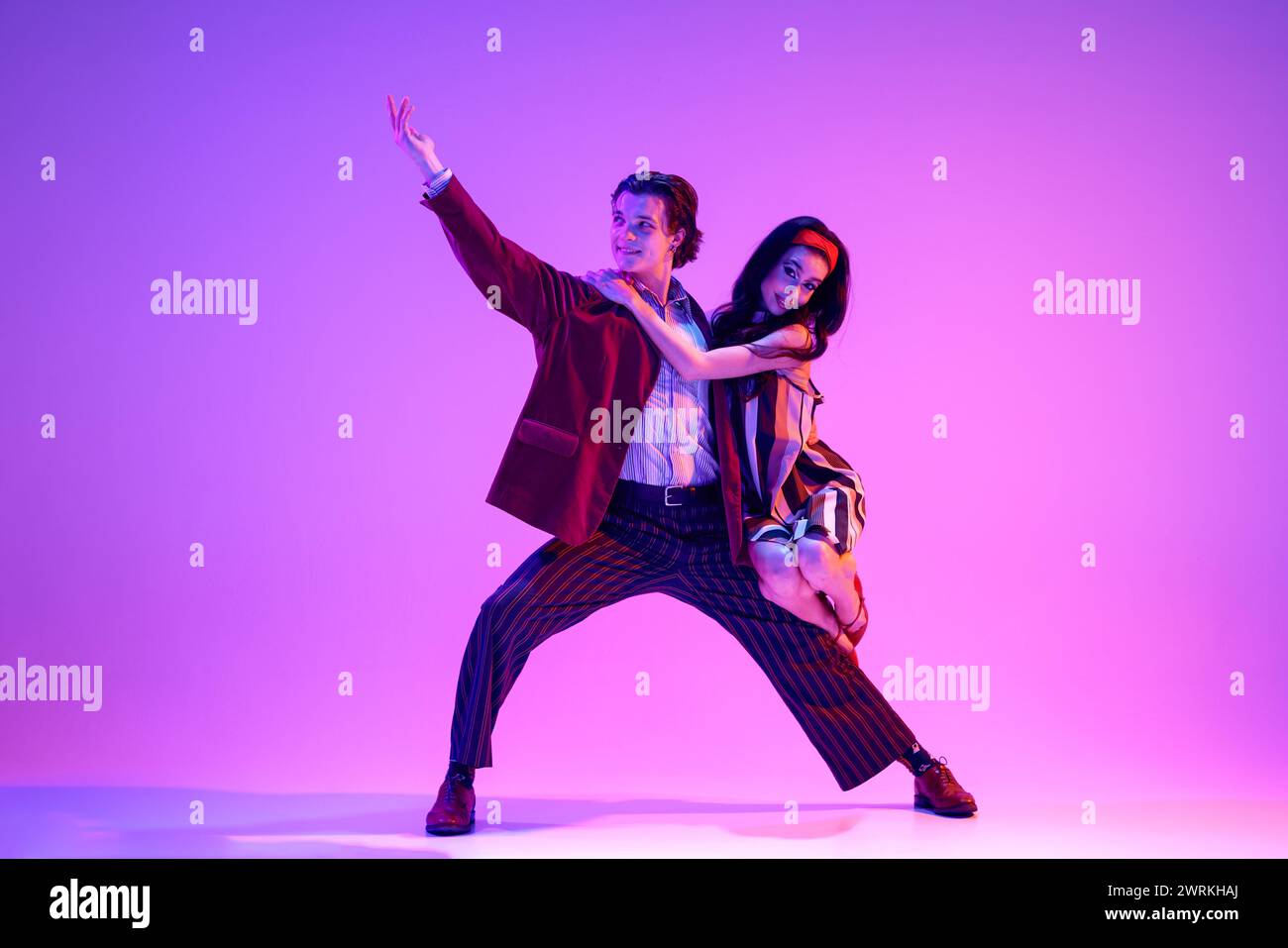 Artistic young man and woman in retro style clothes dancing boogie ...