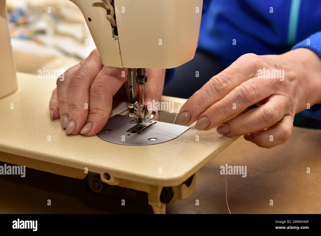 The picture shows the hands of a woman who inserts a bobbin of thread ...