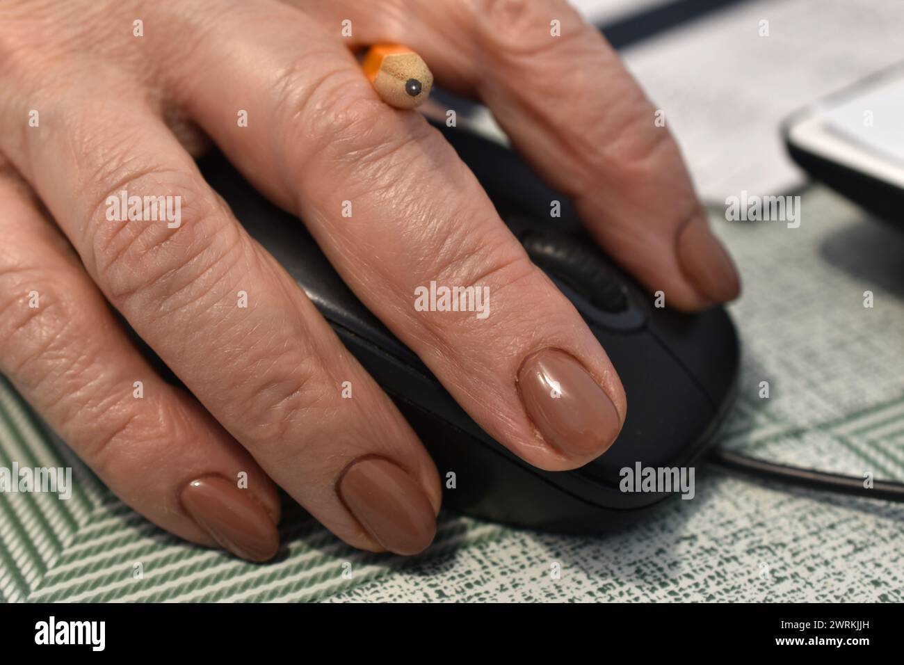 In the close-up picture, a woman's hand, between the fingers of which a ...