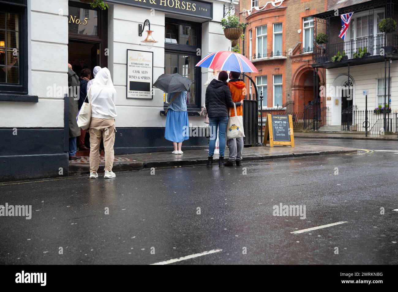 People watch the coronation of King Charles III on screen at a pub in ...