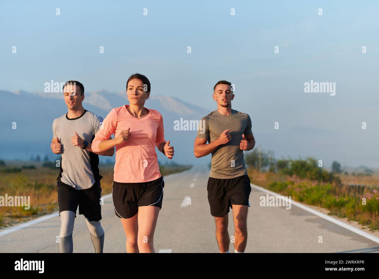 A group of friends, athletes, and joggers embrace the early morning ...