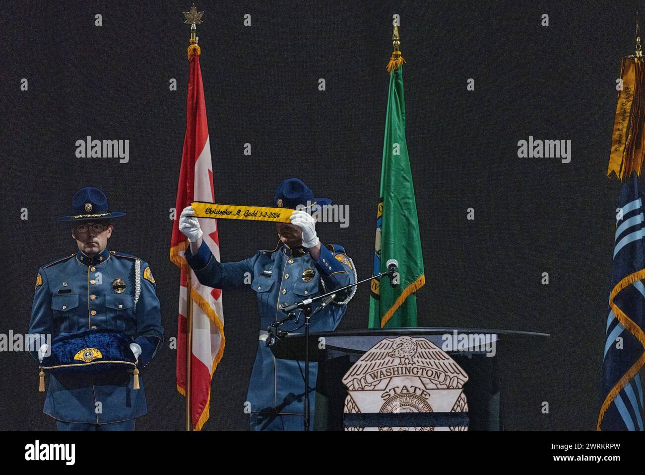 A coworker of Washington State Patrol trooper Chris Gadd holds a ribbon ...
