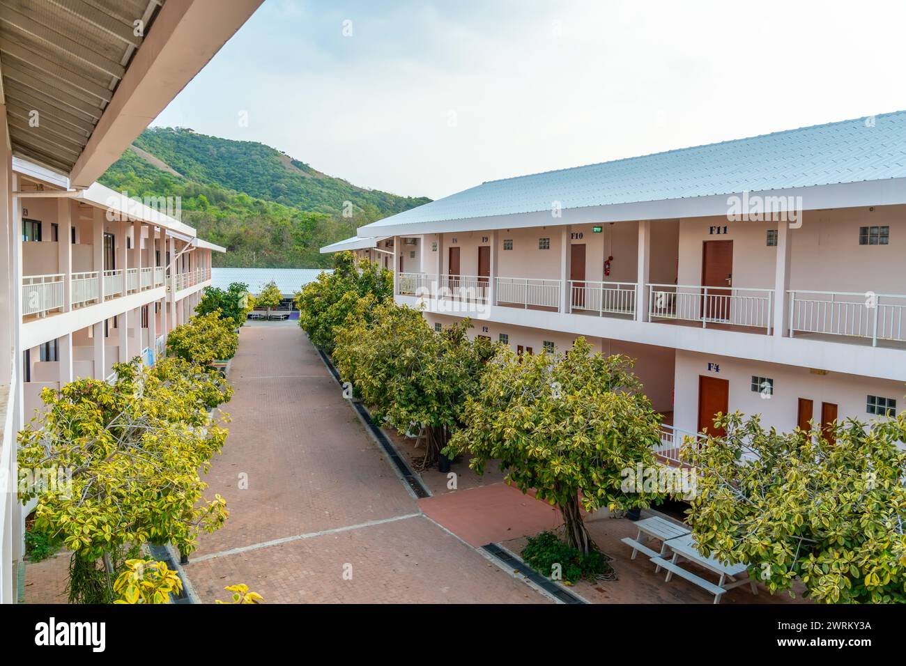 Simple two-story modest hotel on a tropical island with many rooms ...