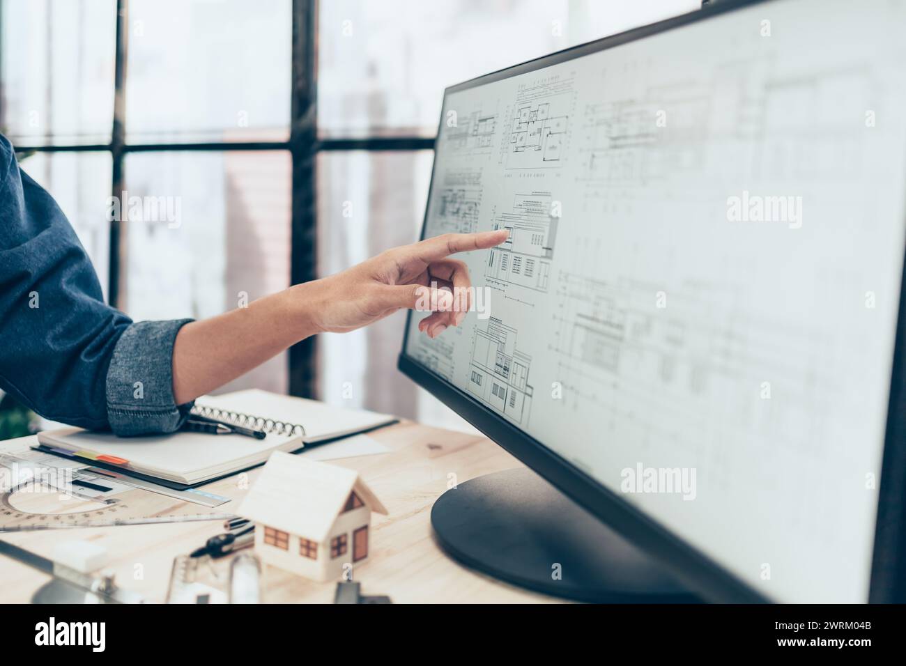 Architect engineer read drawing design and hand pointing to monitor ...