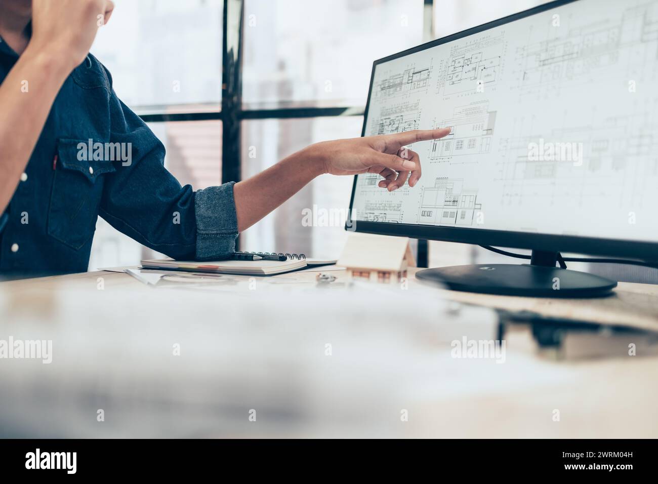 Architect engineer read drawing design and hand pointing to monitor ...