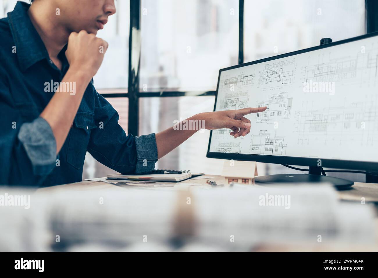 Architect engineer read drawing design and hand pointing to monitor ...
