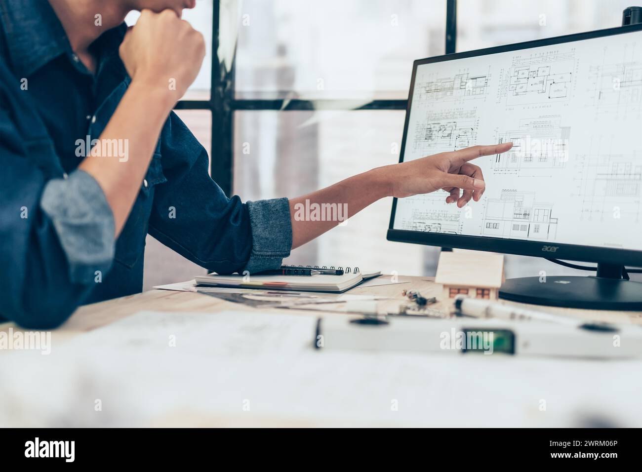 Architect engineer read drawing design and hand pointing to monitor ...