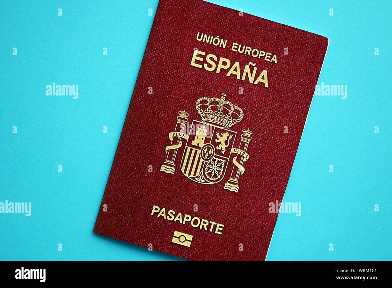 Red Spanish passport of European Union on blue background close up ...