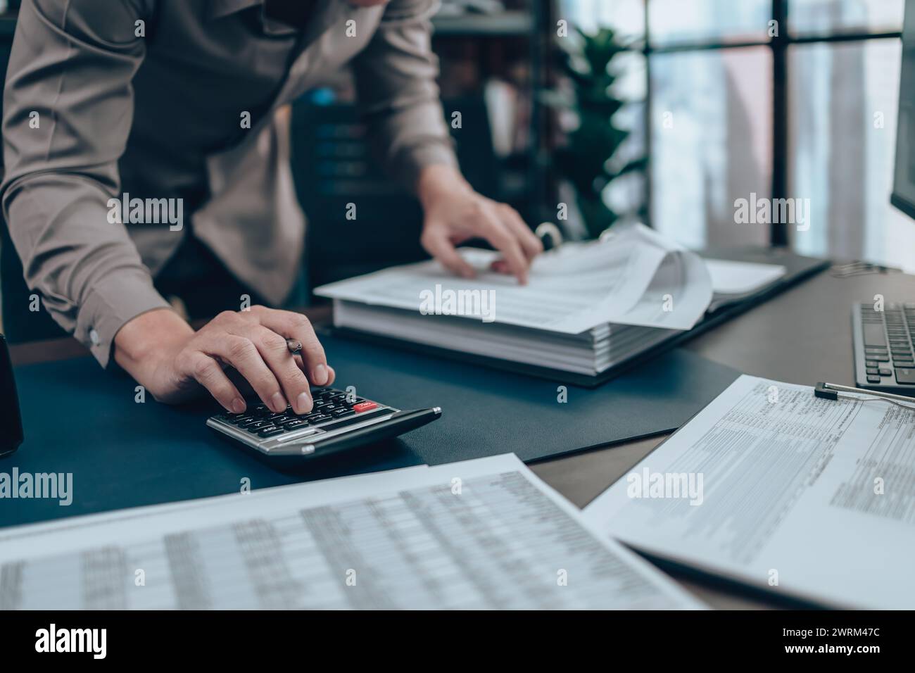 Investors working on desk office and using a calculator to calculate ...