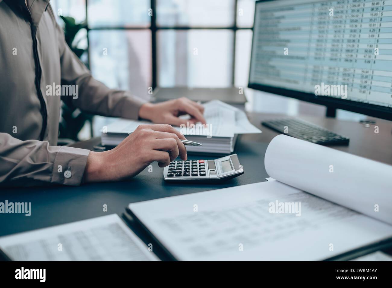 Investors working on desk office and using a calculator to calculate ...