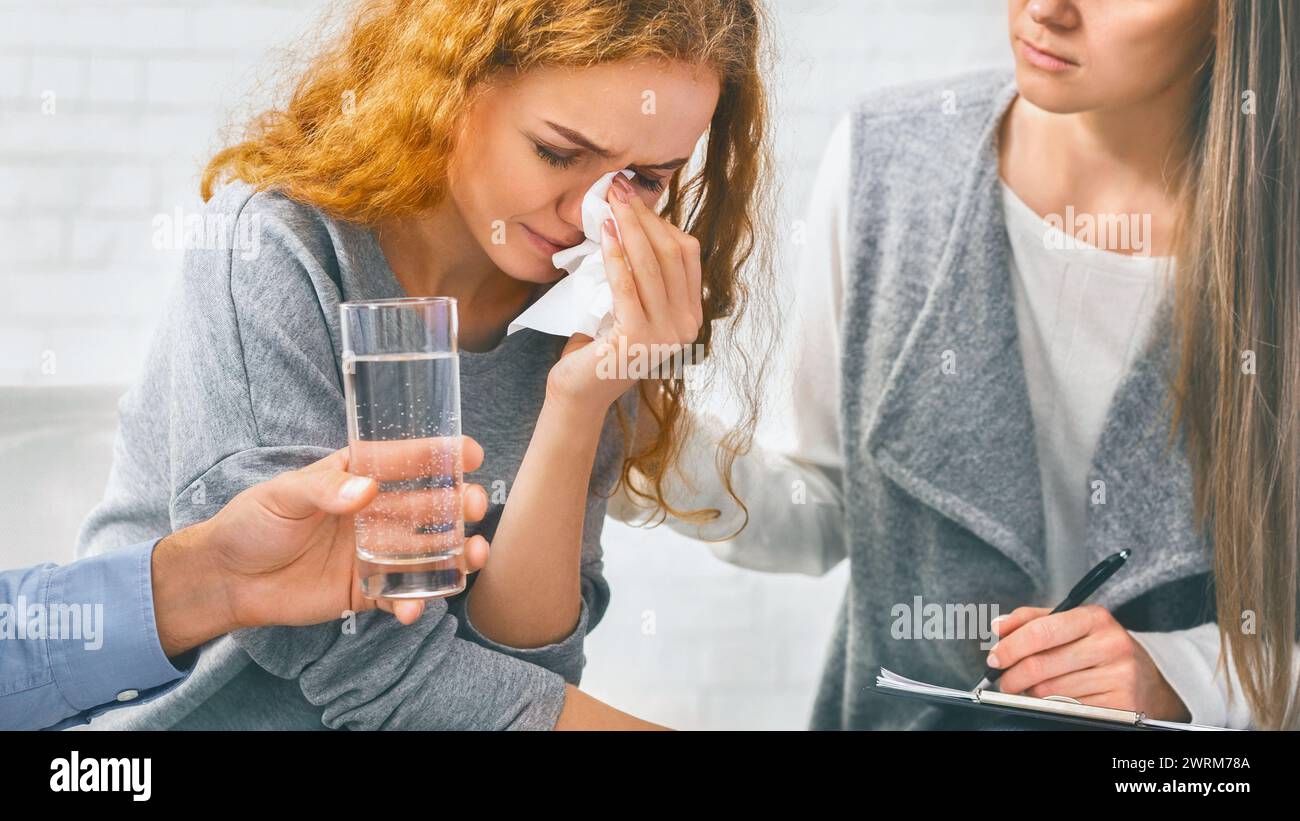 Depressed woman crying at support meeting, therapist comforting her ...