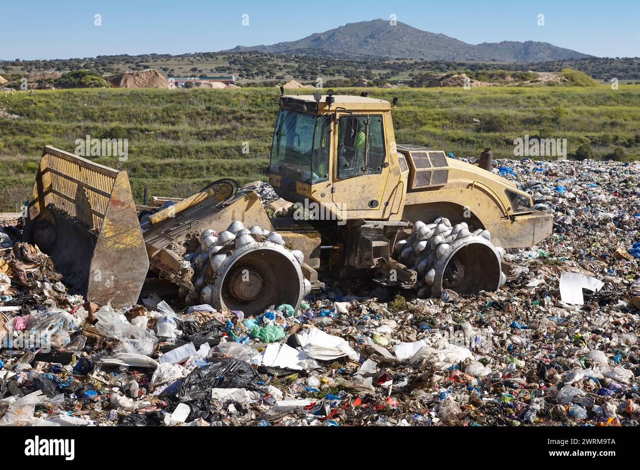 Heavy machinery shredding garbage in an open air landfill. Waste Stock ...