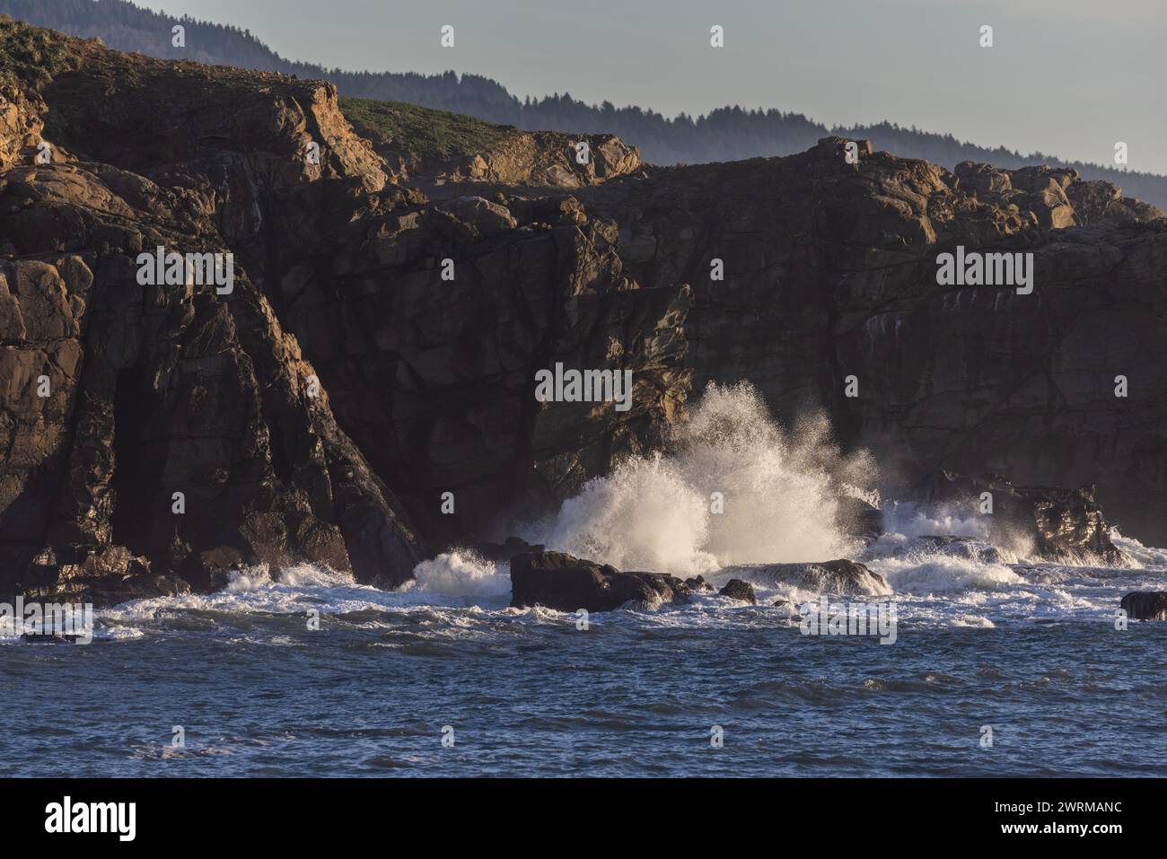 The ocean is crashing against the rocks, creating a powerful and ...