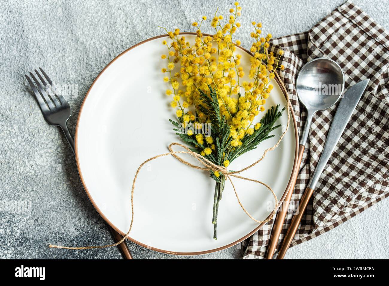 Top view of rustic-chic table setting featuring a delicate mimosa ...
