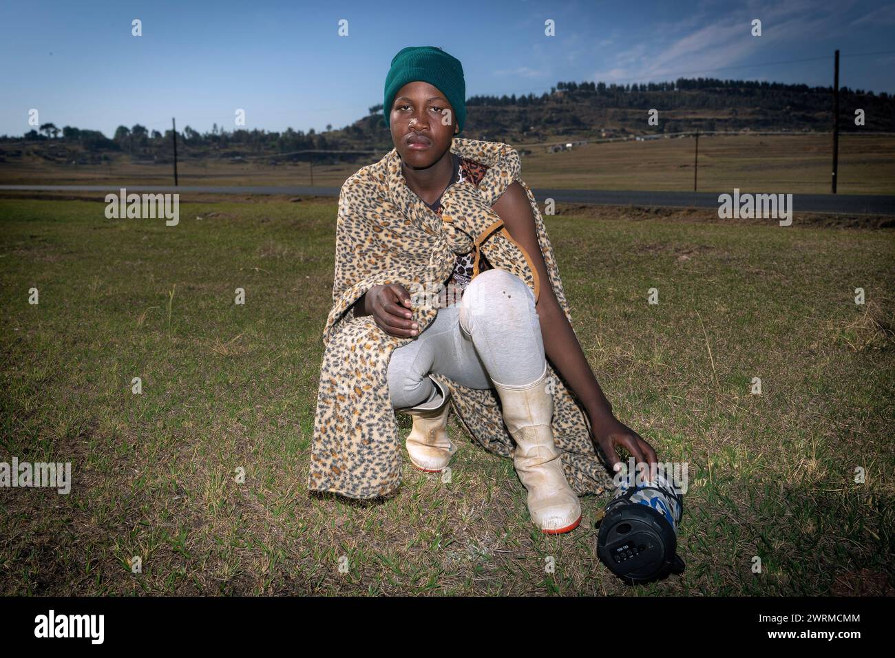 A shepherd tending his sheep holding a portable stereo. A Lesothan on ...
