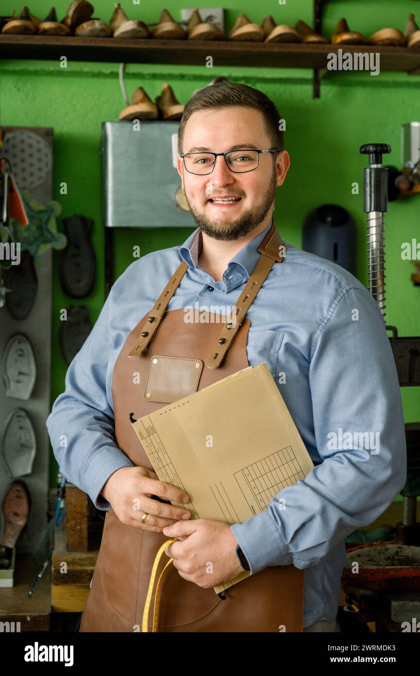 An Austrian shoemaker smiling proudly in his workshop, clad in a blue ...