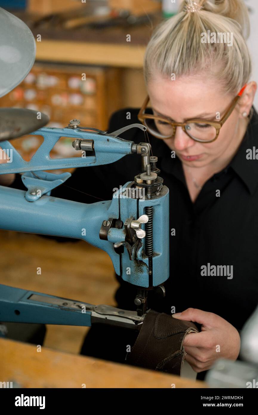 An Austrian shoemaker uses a sewing machine to meticulously stitch ...
