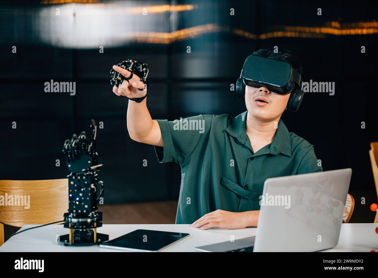 Asian teenager wears VR glasses controlling a robot arm project in a ...
