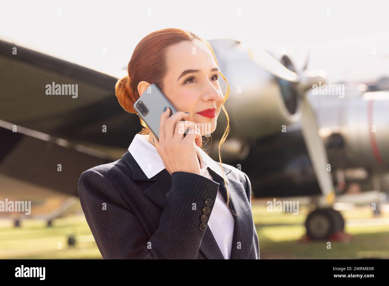 A poised air hostess is captured in a moment of communication, making a ...