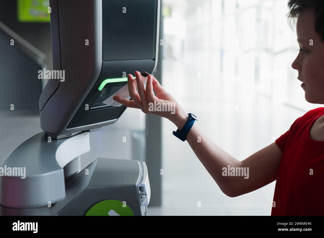 A young boy uses a ticket reading machine to access a science museum ...