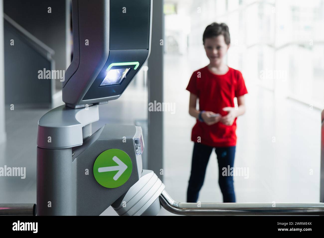A young boy smiles as he uses a modern ticket reading machine at the ...