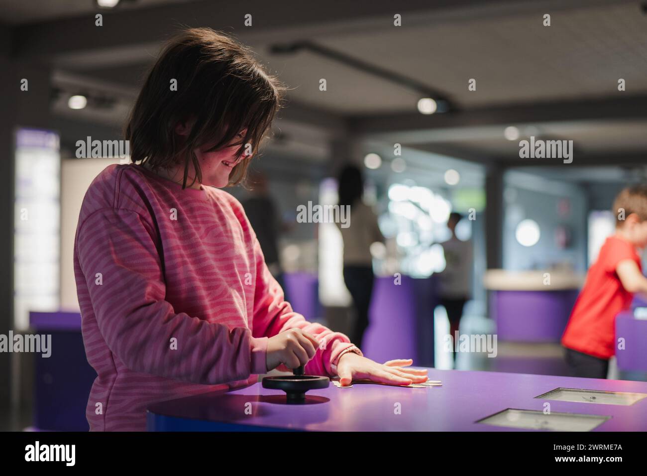 A boy and girl engage with hands-on displays at a science museum ...