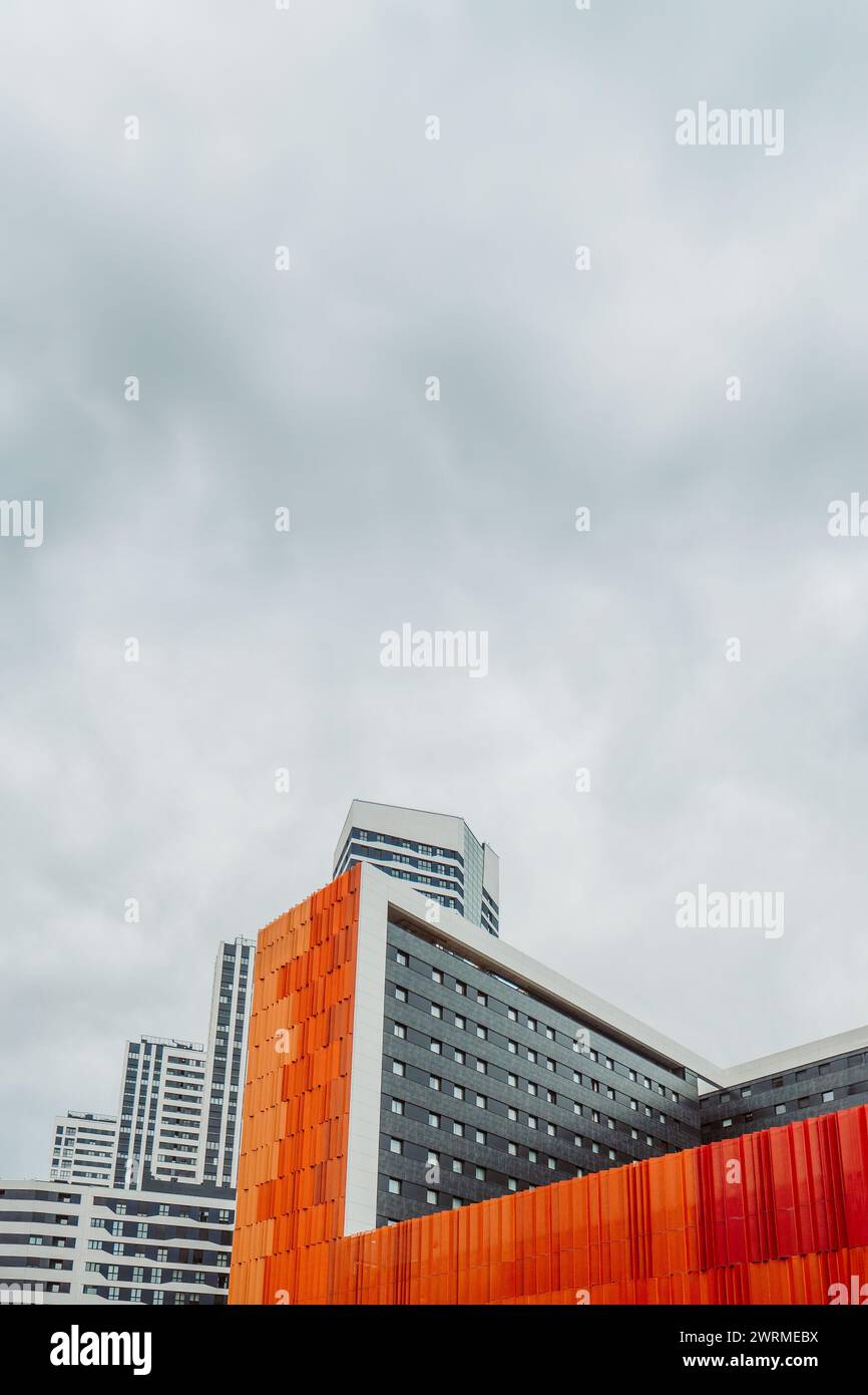 Modern buildings with vibrant orange cladding stand out against a ...