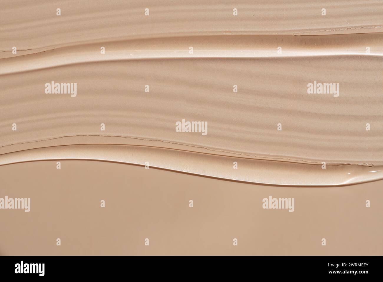 A close-up view of smooth, beige-colored cosmetic foundation swatches ...