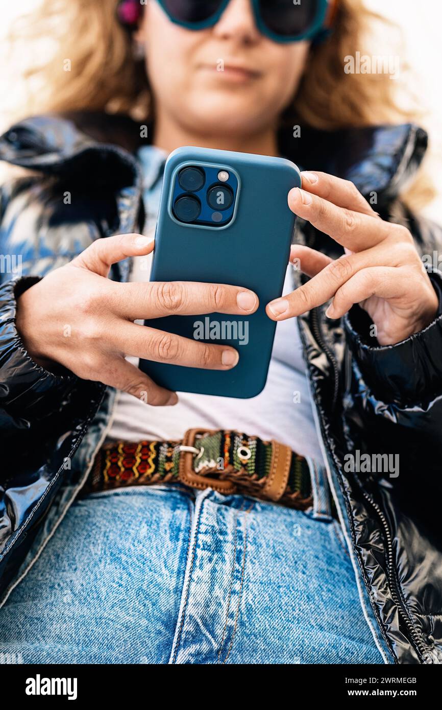 A stylish individual interacts with a smartphone using a distinctive ...