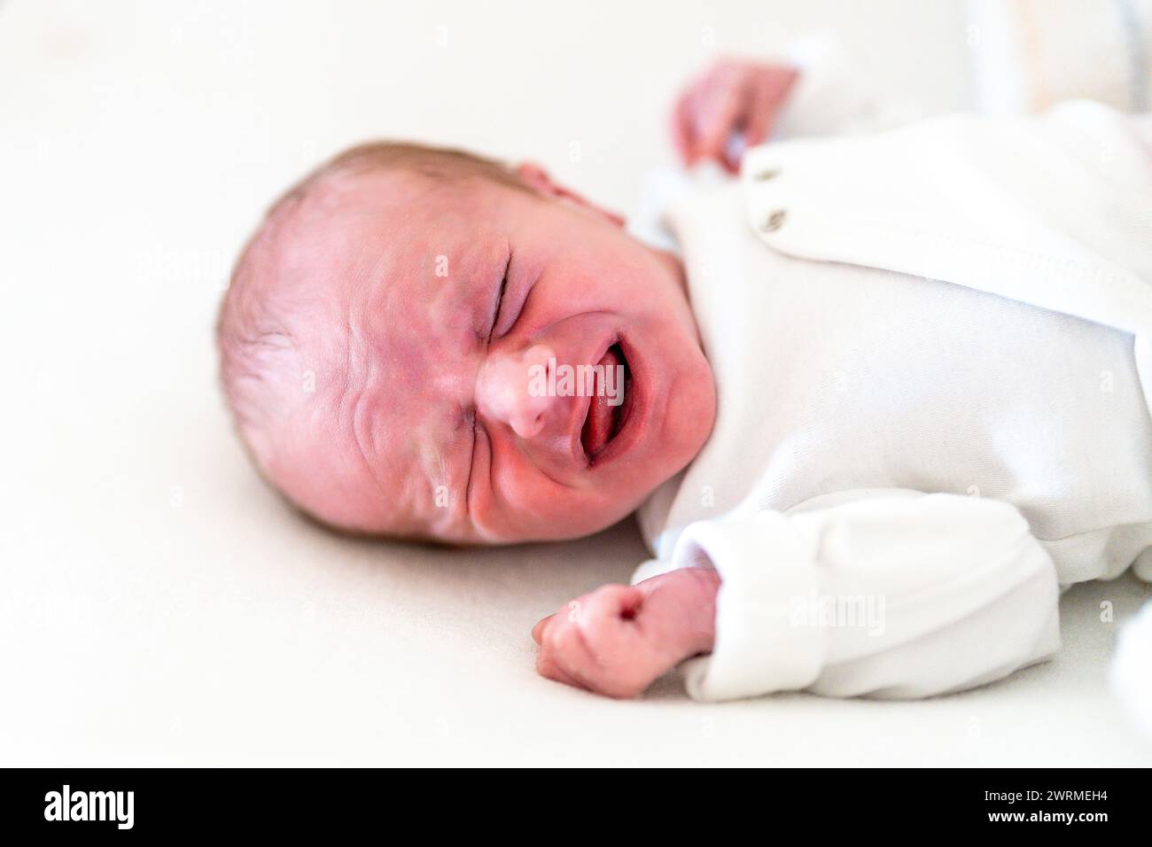 A close-up image capturing the raw emotion of a newborn baby crying ...