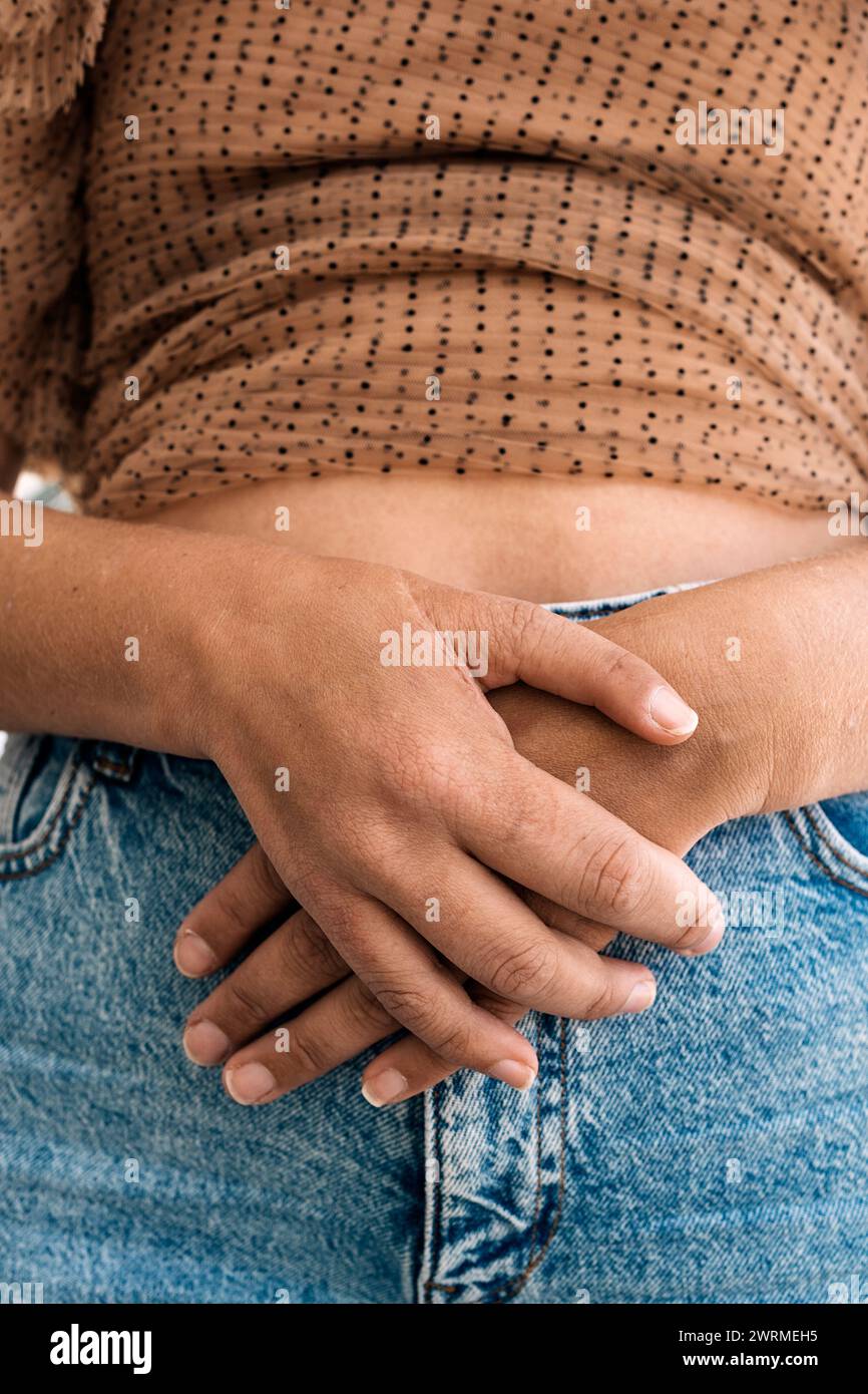 A detailed view of anonymous person's hands clasped together, one ...