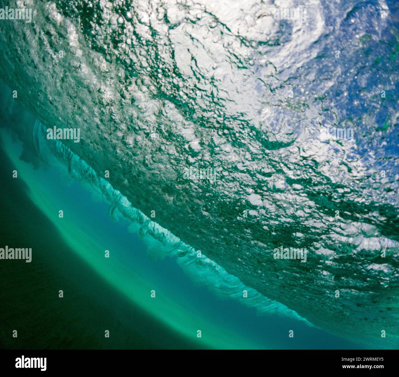 The underside of a powerful wave captured in exquisite detail, highlighting the textures and ...