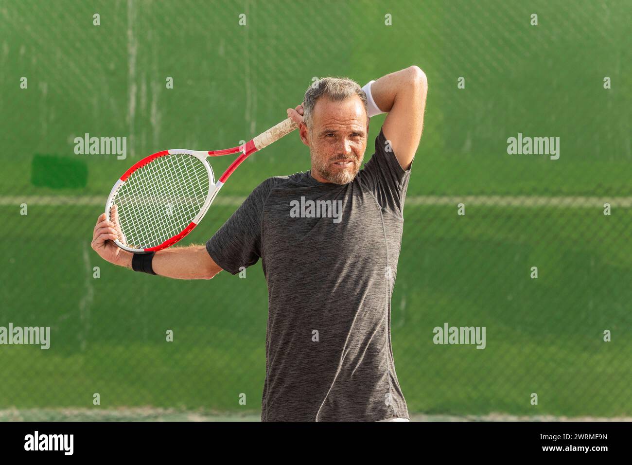 Mature man gripping tennis racket hi-res stock photography and images ...
