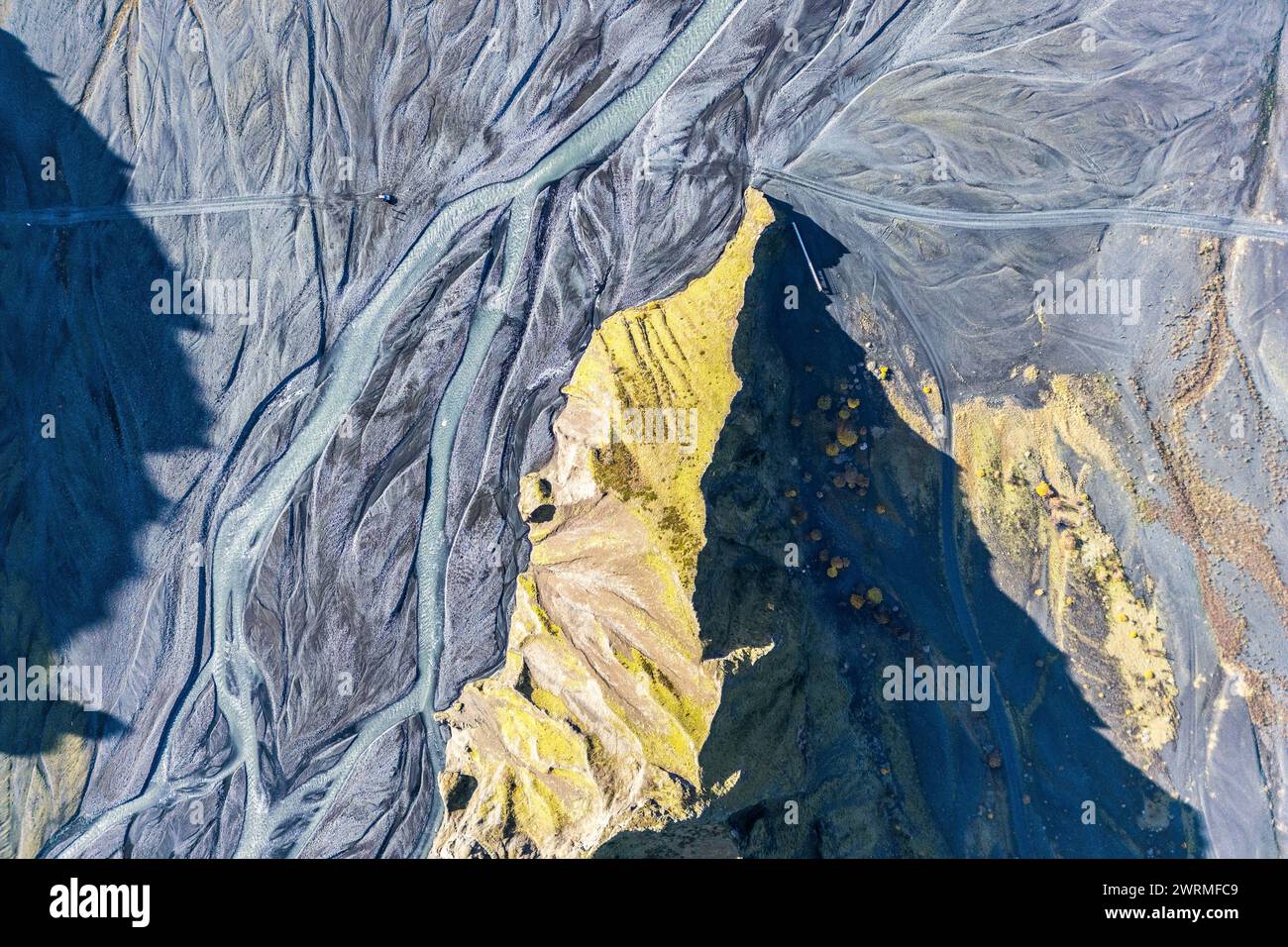 This aerial shot captures the striking contrasts of a river winding ...