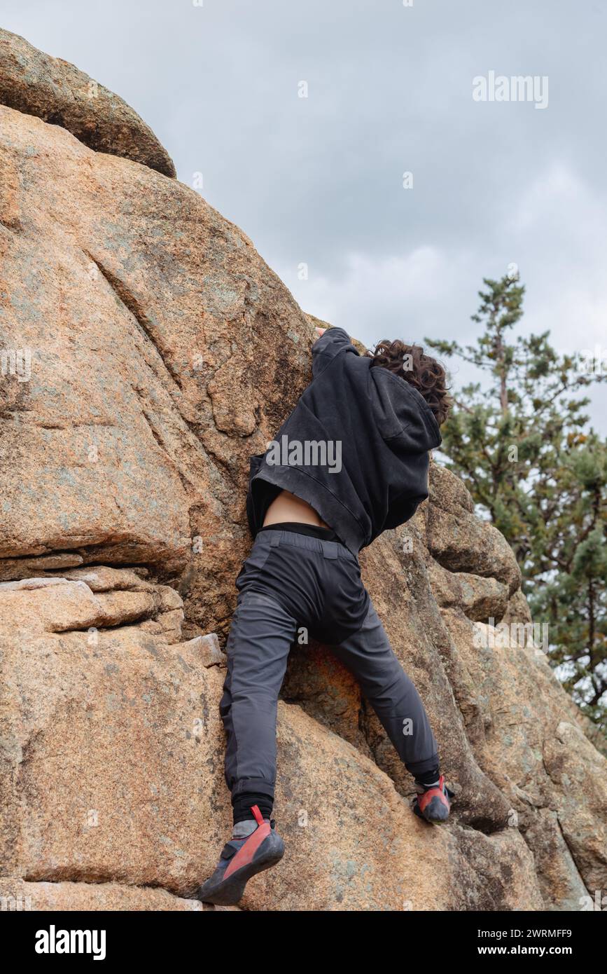 Focused and determined, a climber makes upward progress on a textured ...
