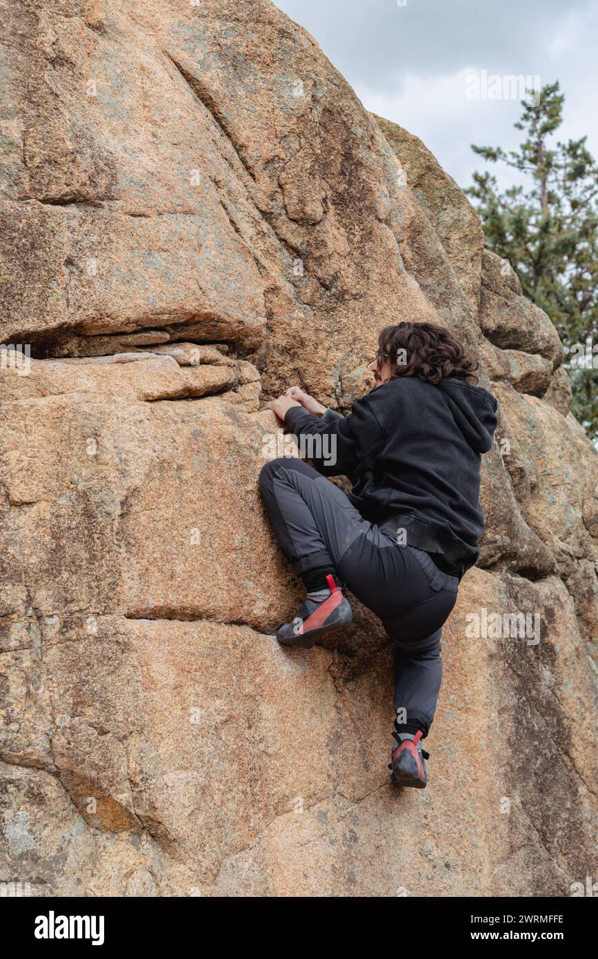 Focused climber makes their way up a steep cliff, demonstrating skill ...