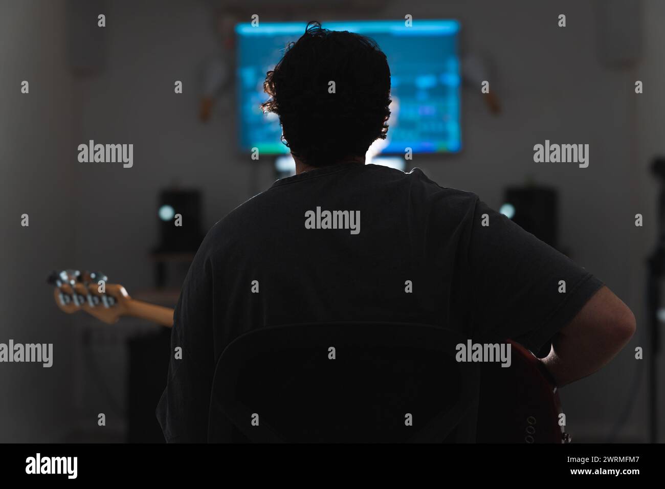 Back view of unrecognizable male musician is seen from behind, holding ...