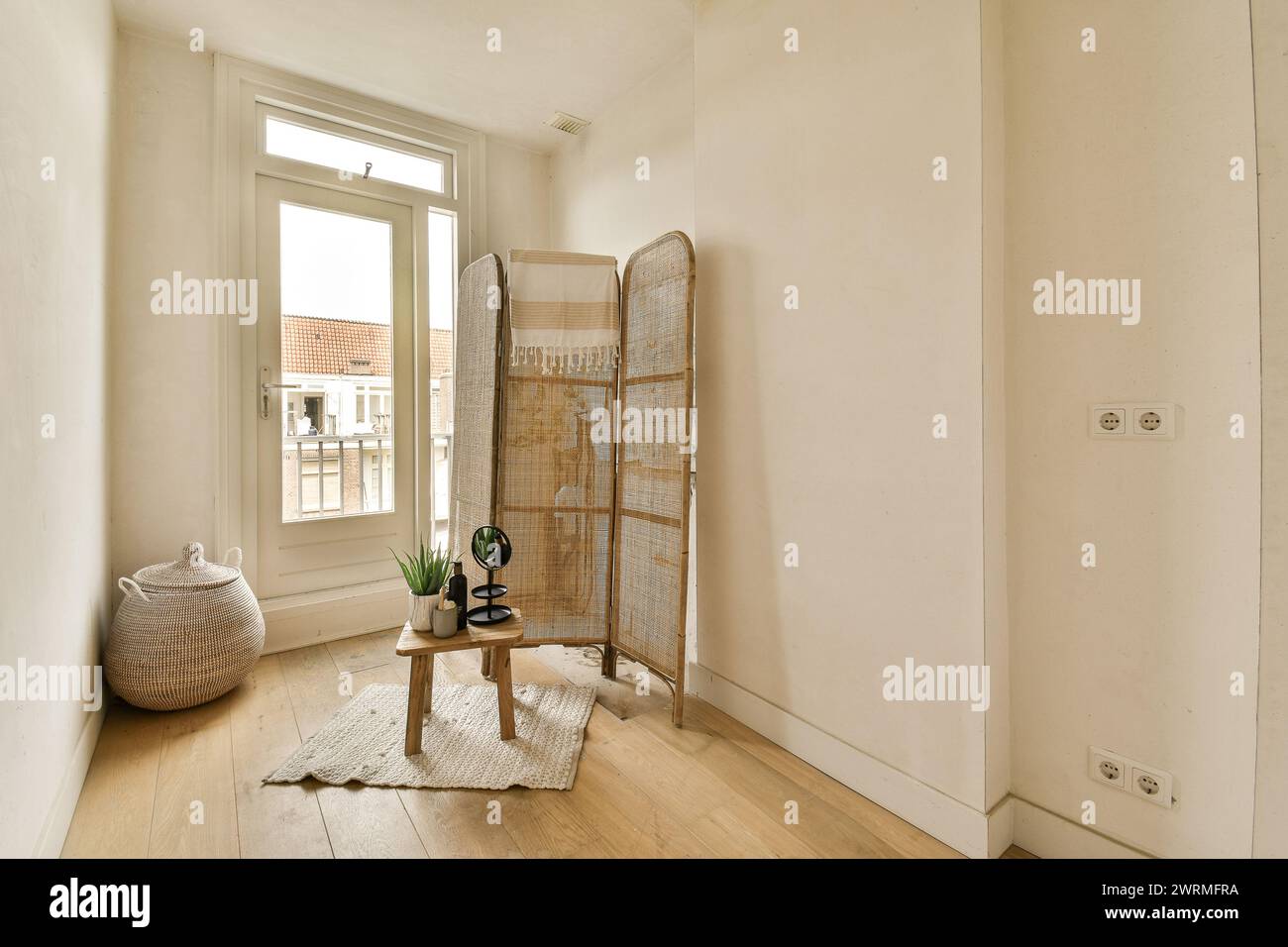 A tranquil corner in a bright room featuring a folding privacy screen ...